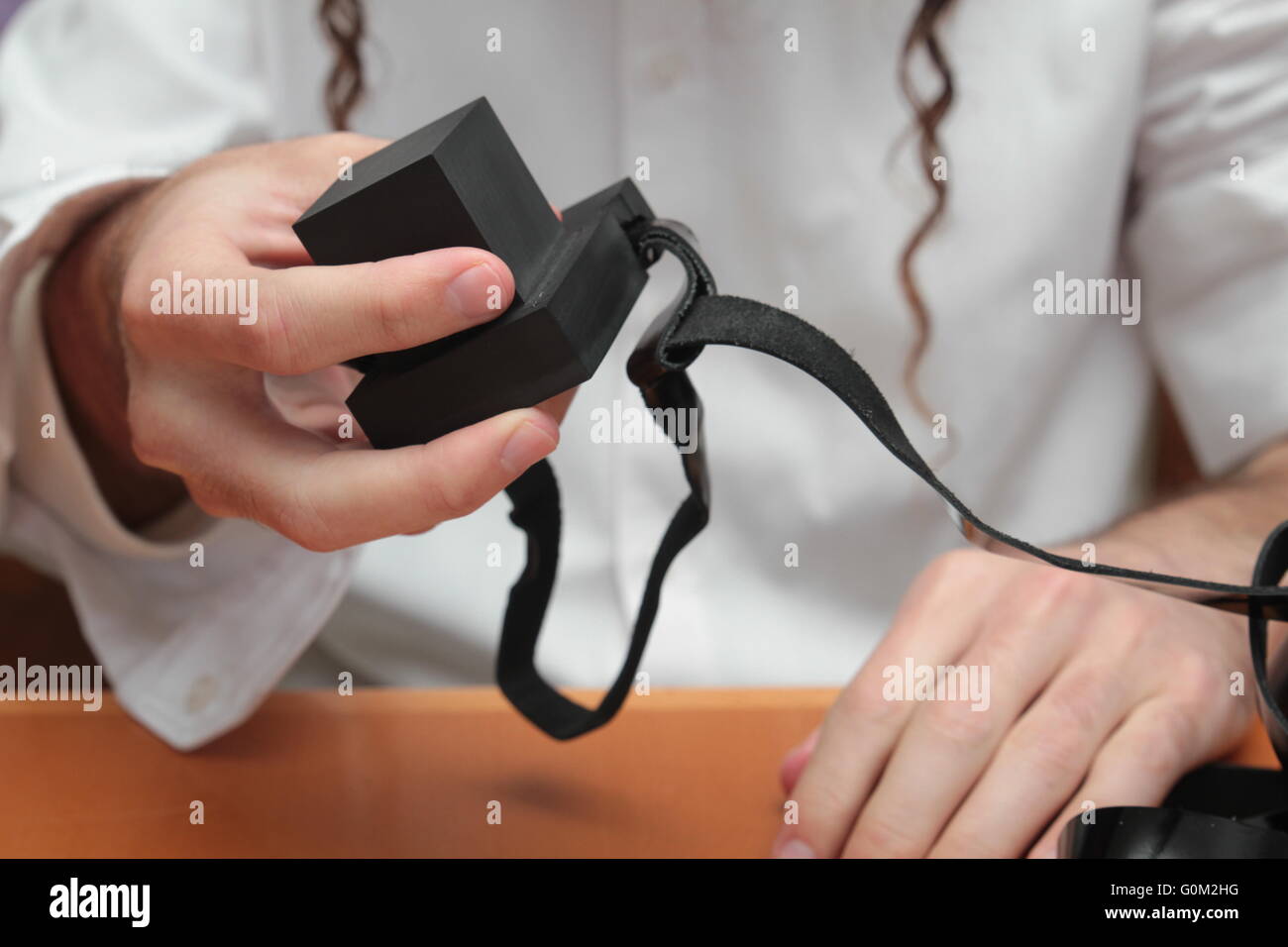 Jewish Man wrapped in tefillin pray . A religious orthodox Jew with arm ...