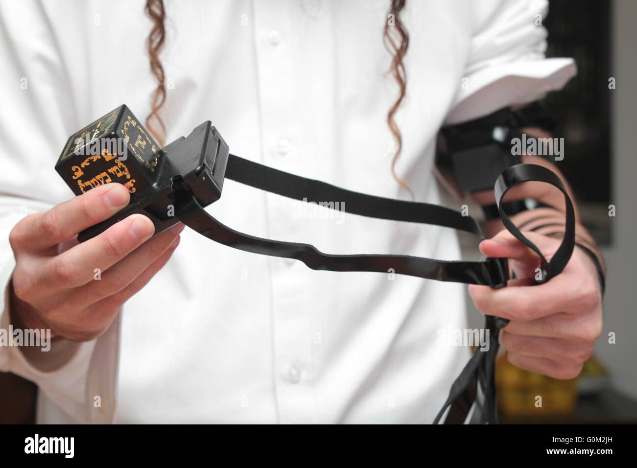 Jewish Man wrapped in tefillin pray . A religious orthodox Jew with arm ...
