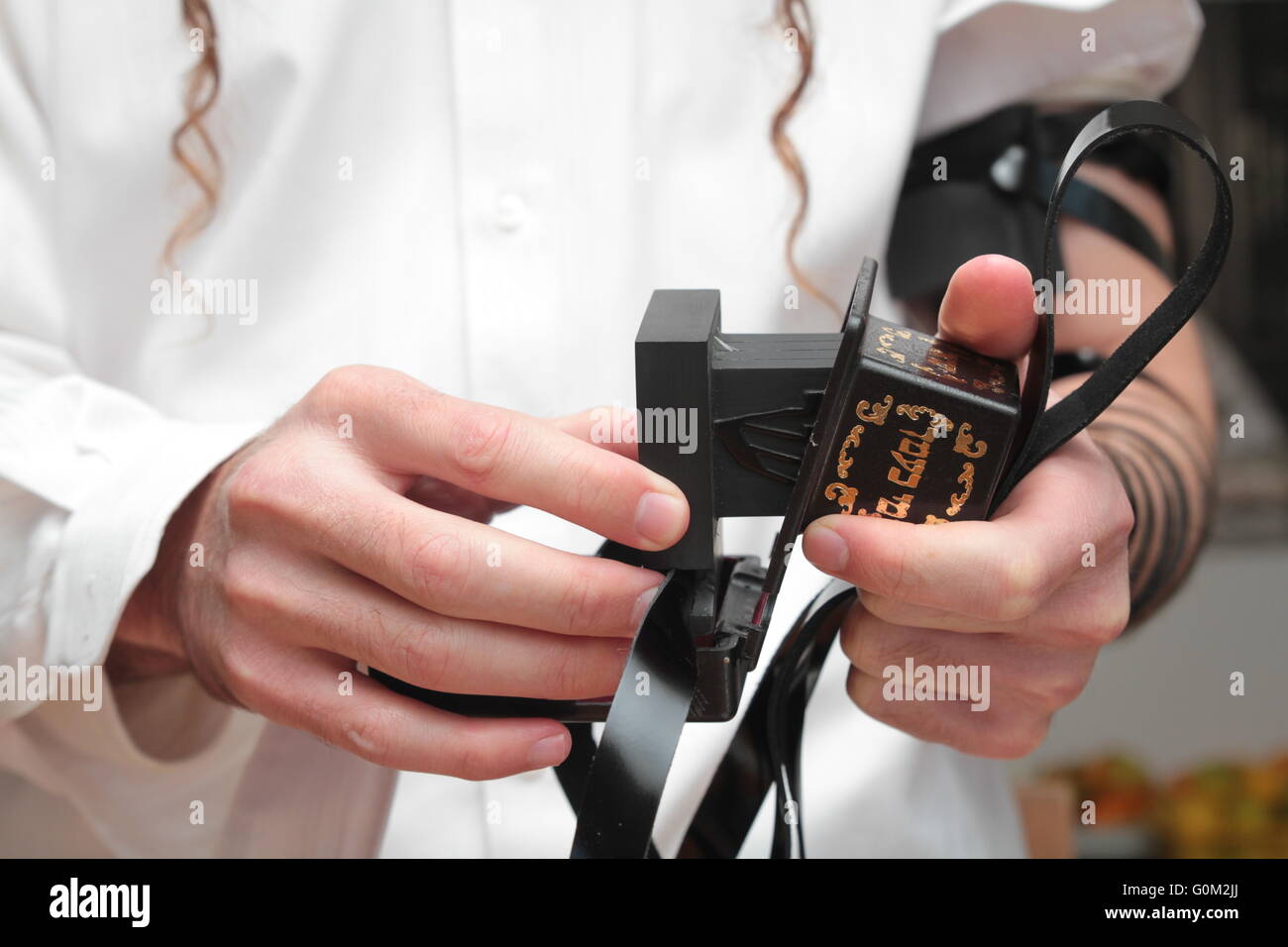 Jewish Man wrapped in tefillin pray . A religious orthodox Jew with arm ...