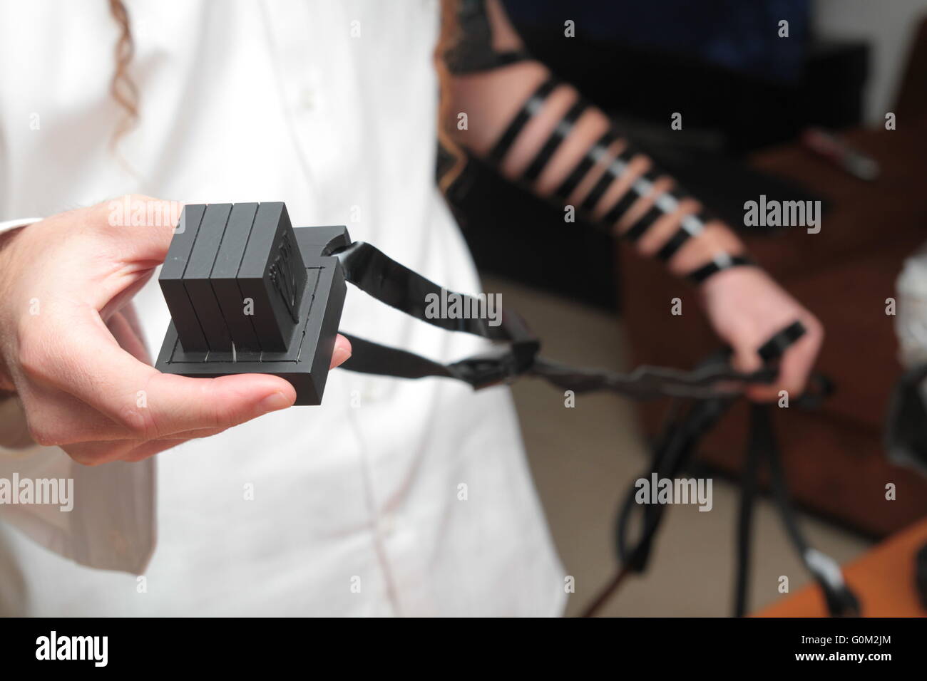 Jewish Man wrapped in tefillin pray . A religious orthodox Jew with arm ...