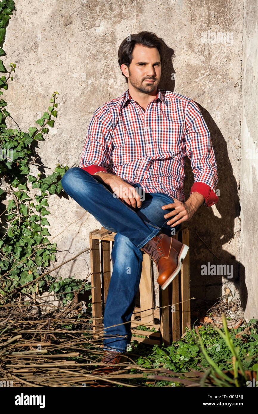 Male model sitting with legs crossed Stock Photo - Alamy