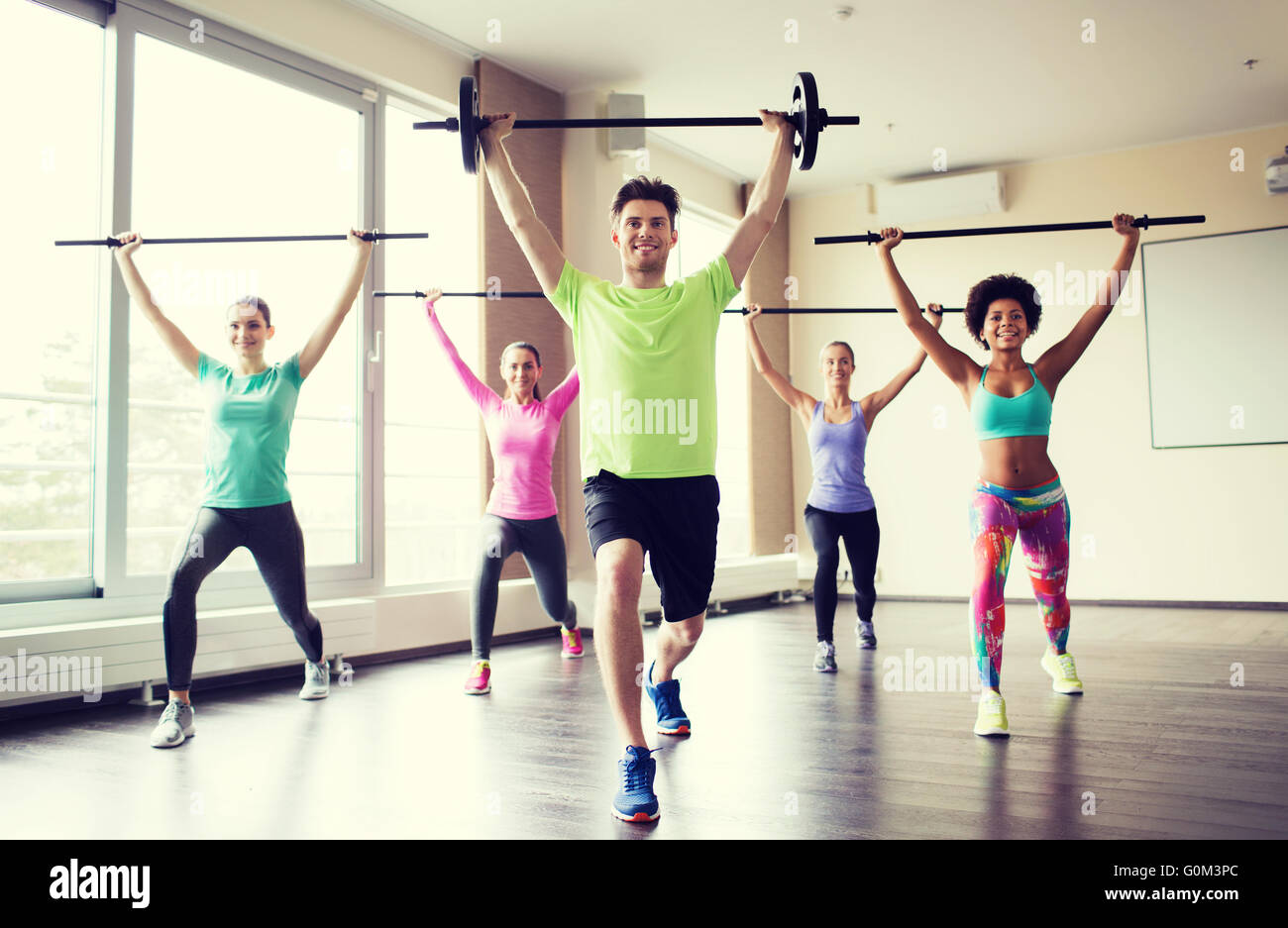 group of people exercising with bars in gym Stock Photo - Alamy