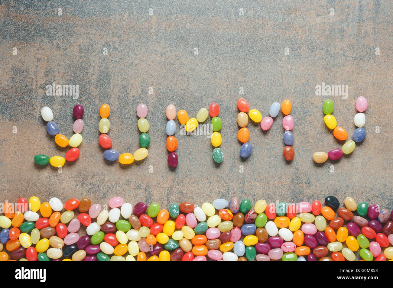 Word yummy written with jelly beans, dark background with colorful ...