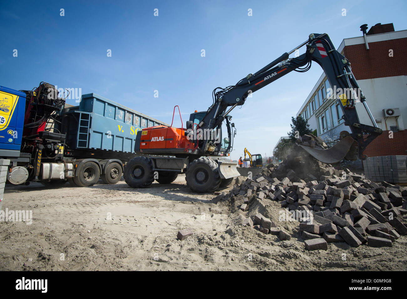 Excavator shoveling bricks Stock Photo - Alamy