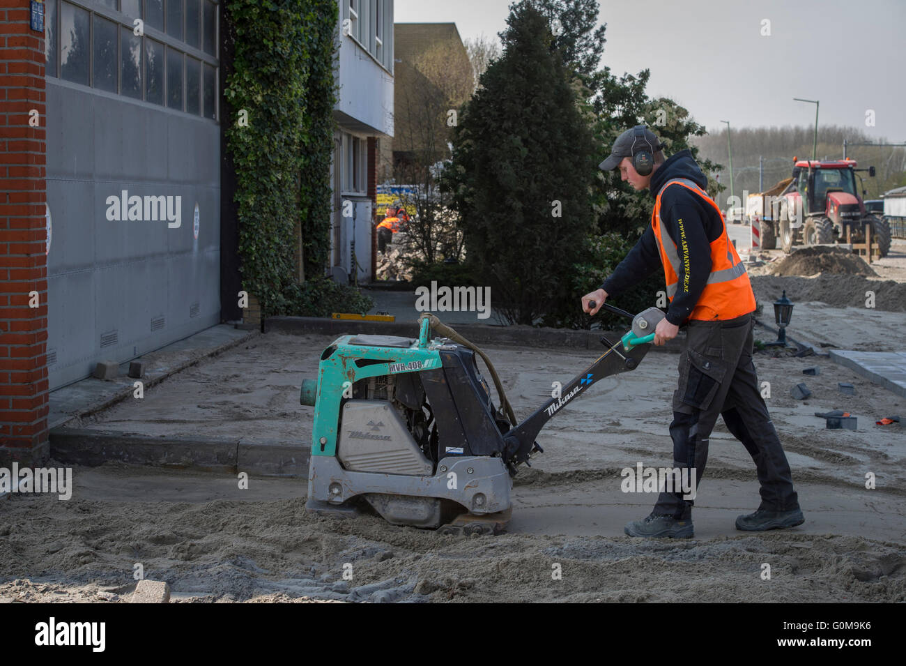 A man working on infrastructure. Paving the street Stock Photo - Alamy