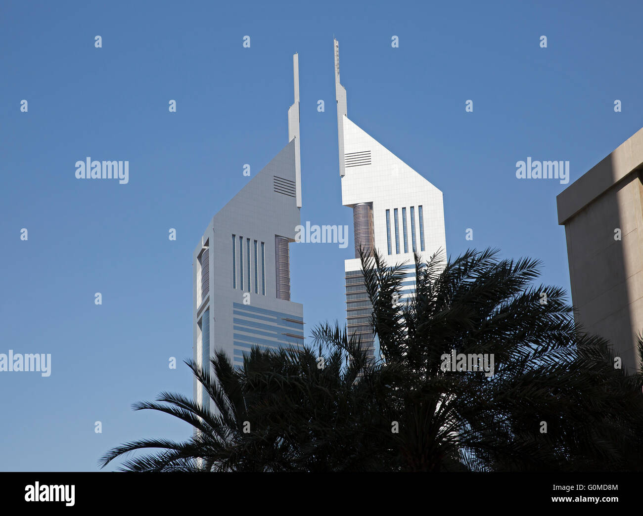 Emirates Towers behing palm trees in Dubai UAE Stock Photo - Alamy