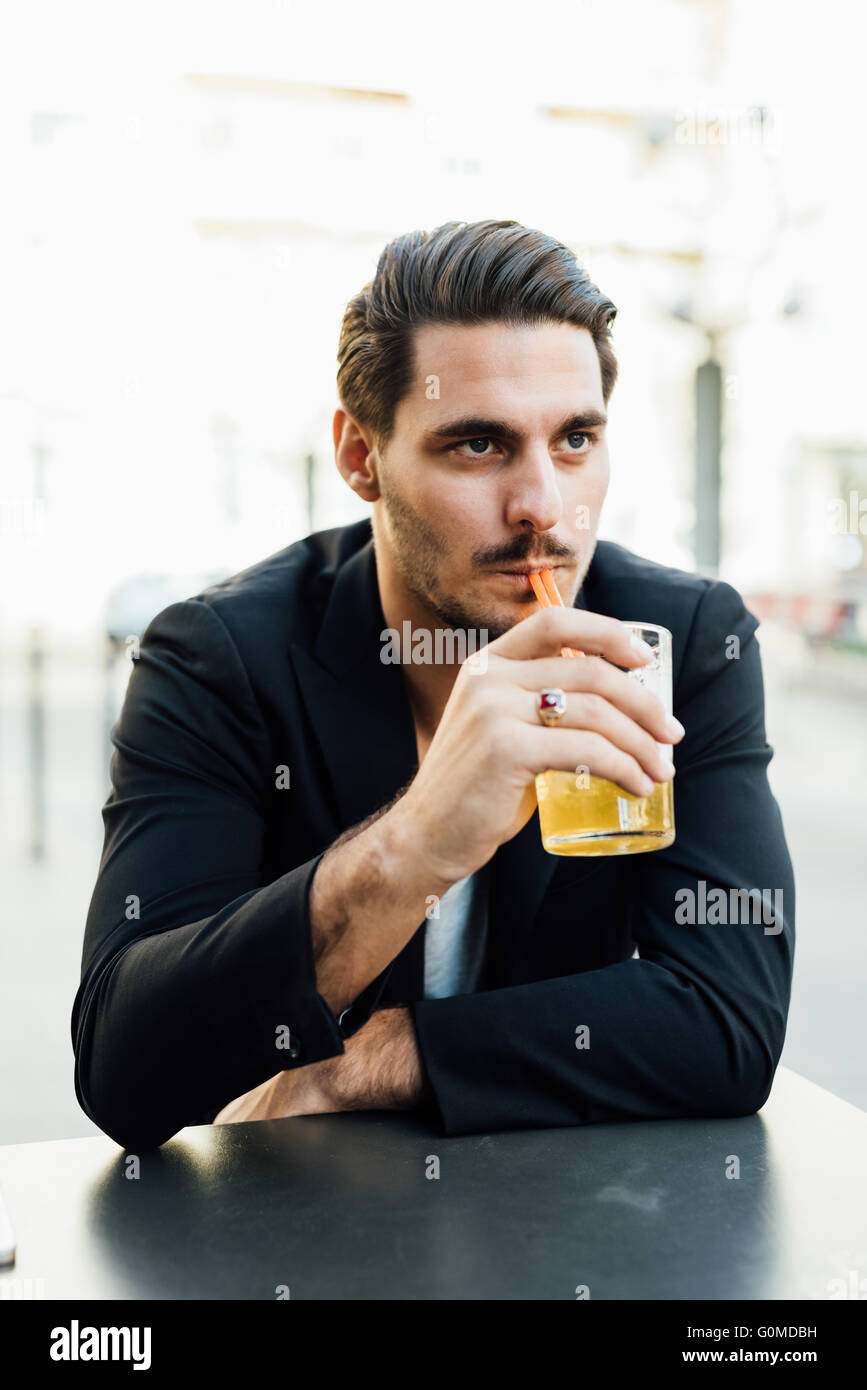 Young handsome italian boy having an happy hour seated on a bar in the ...