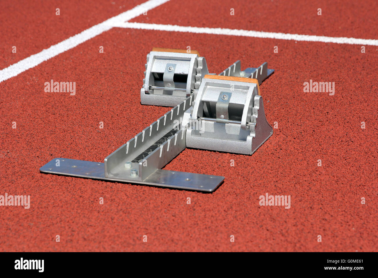 Athletics starting blocks on race track Stock Photo - Alamy