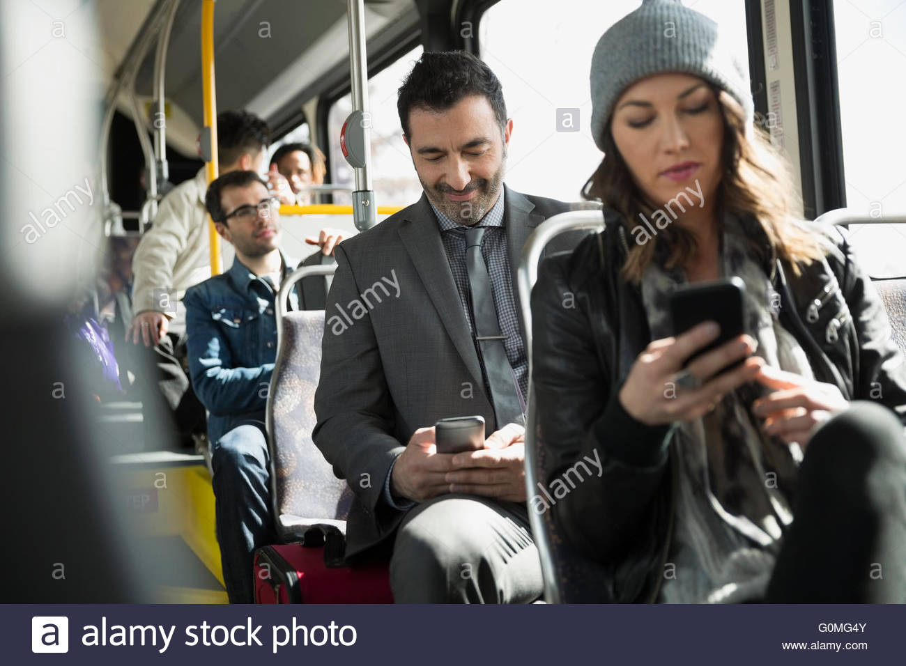 People using cell phones on bus Stock Photo - Alamy