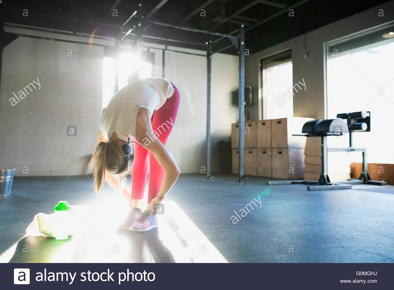 Woman stretching in forward fold at gym Stock Photo - Alamy