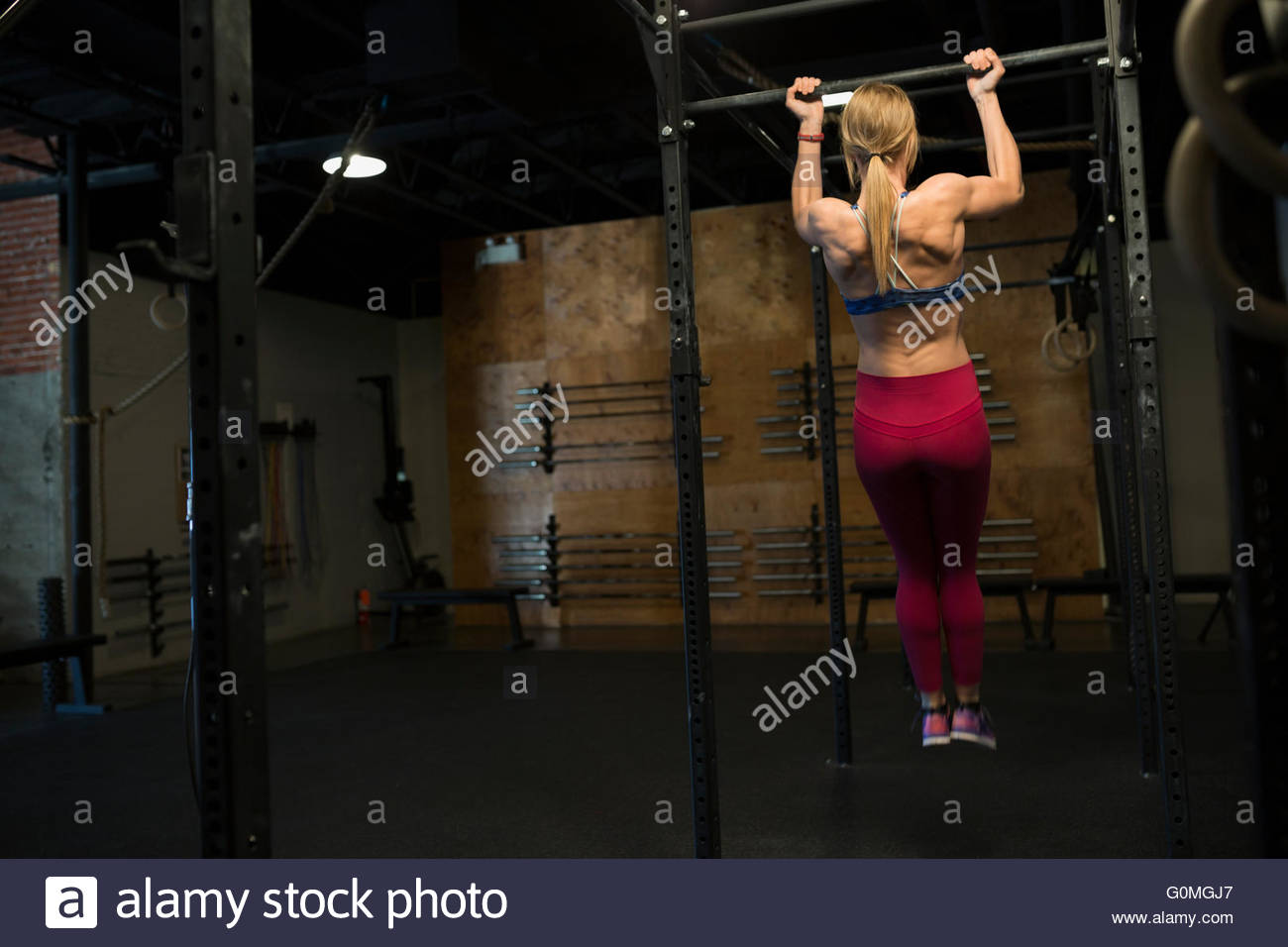 Woman doing pull-ups at gym Stock Photo - Alamy
