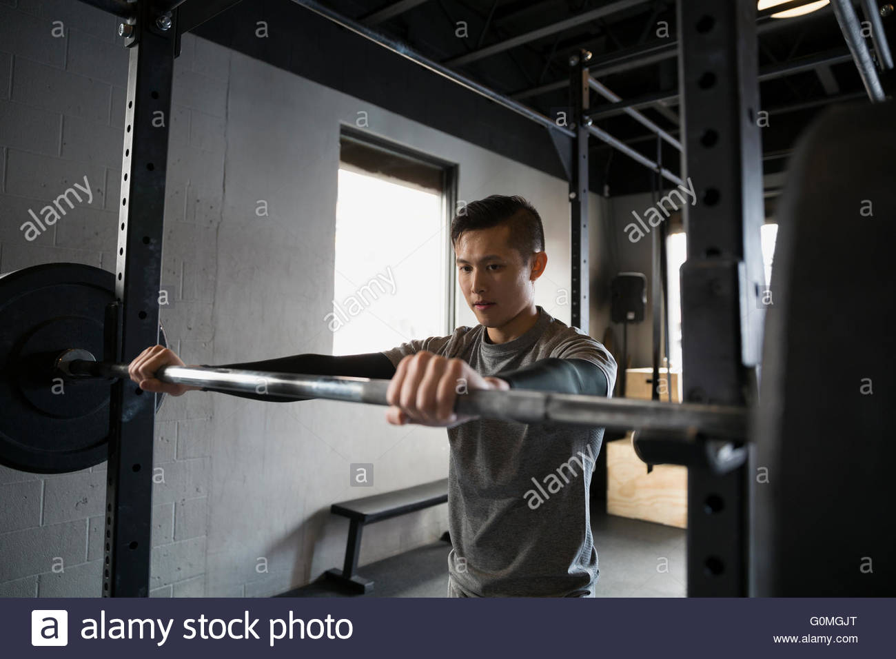 Man at barbell rack at gym Stock Photo - Alamy