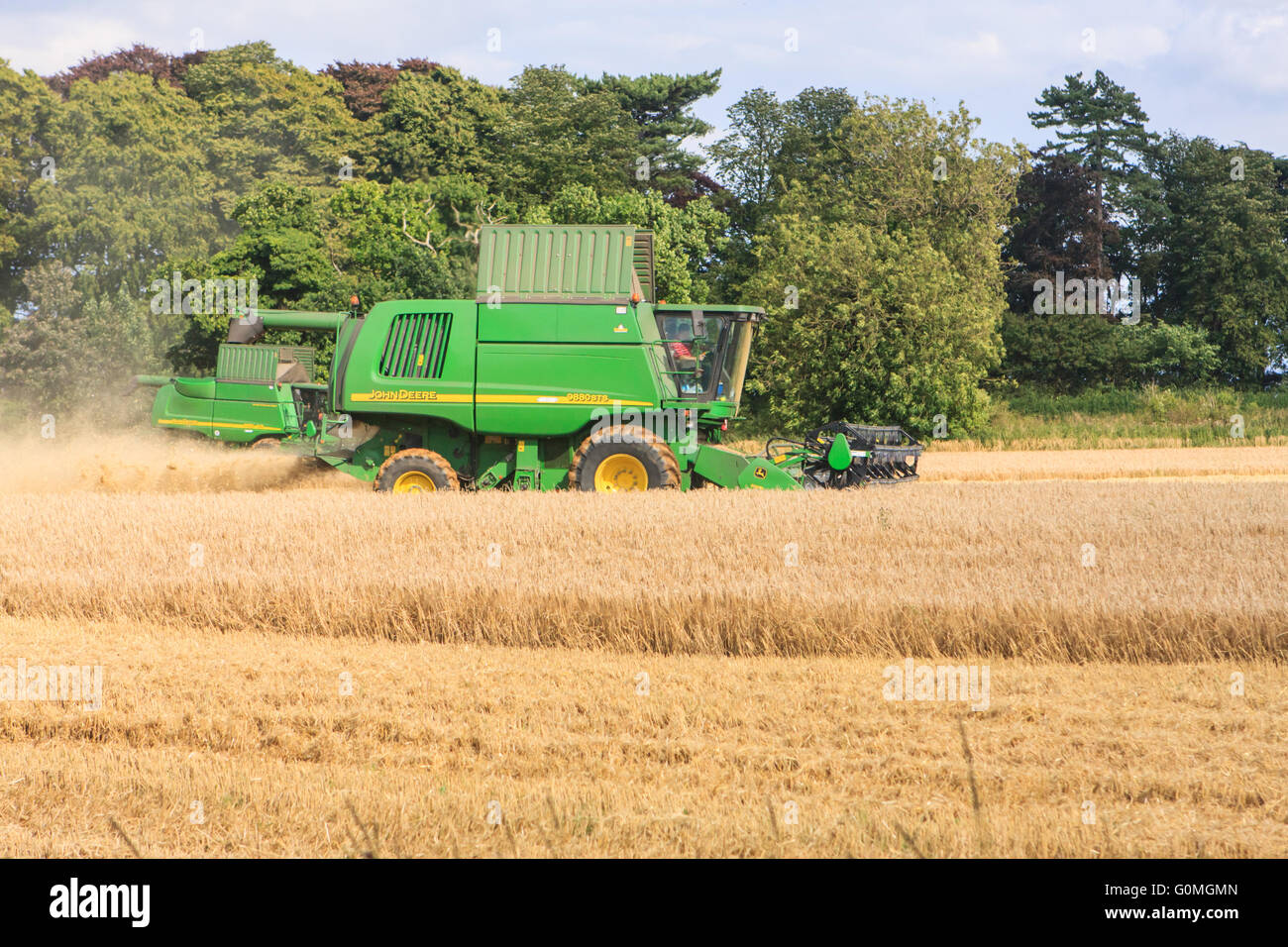 John Deere combine harvester harvesting corn summer in the UK Stock ...