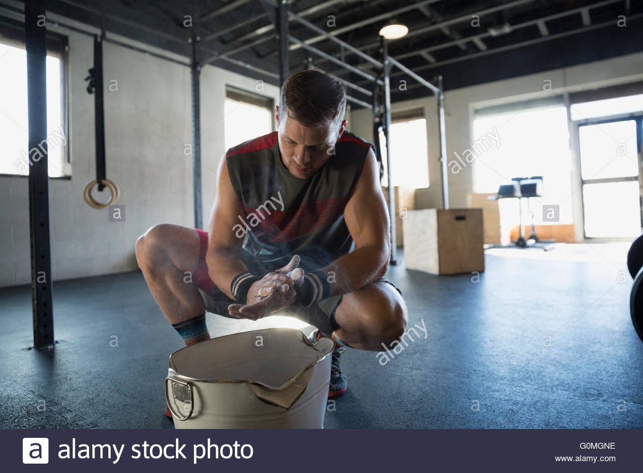 Man chalking hands before weightlifting at gym Stock Photo - Alamy