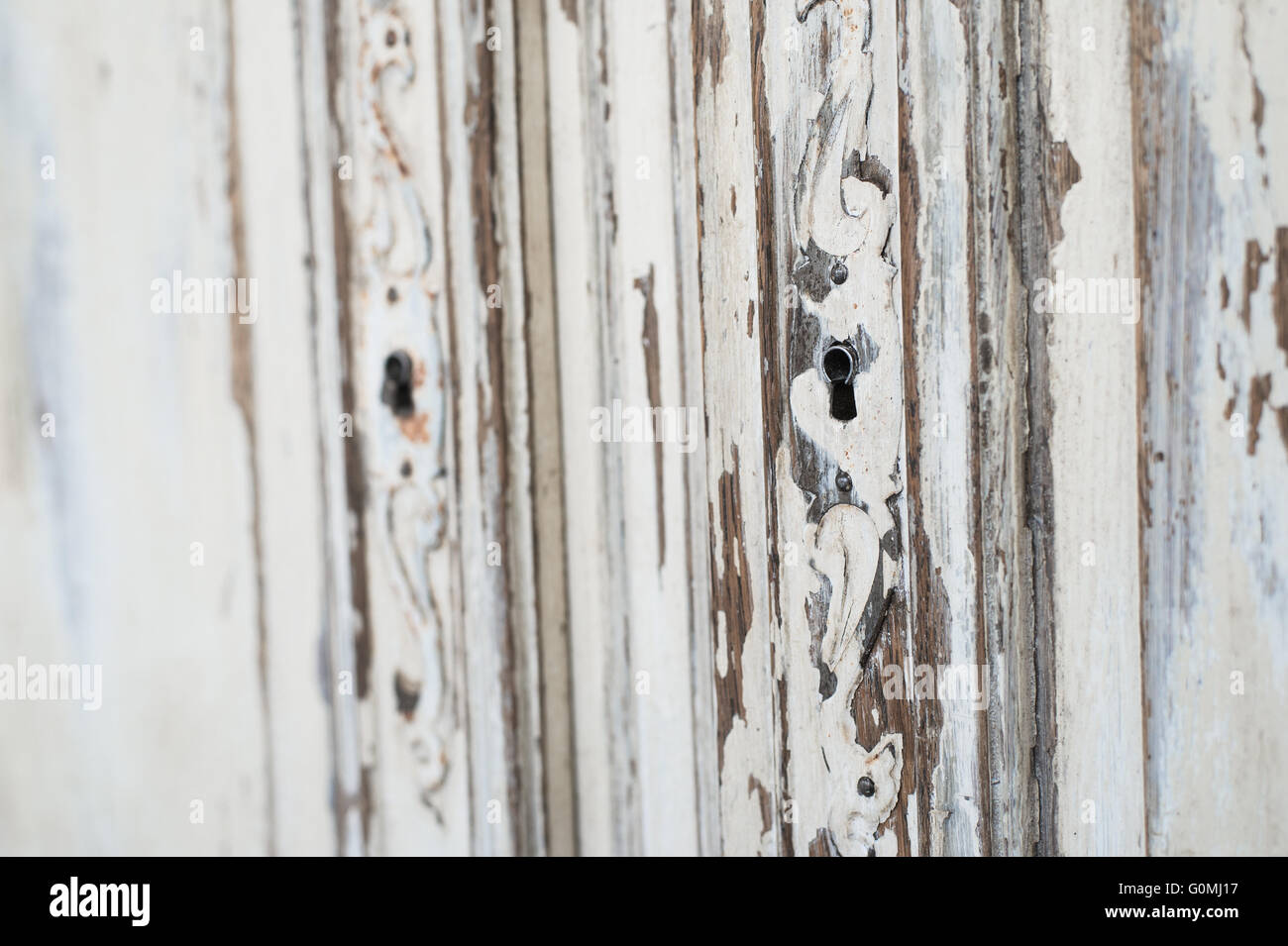 Close-up of keyhole ancient white commode bureau furniture with paint ...