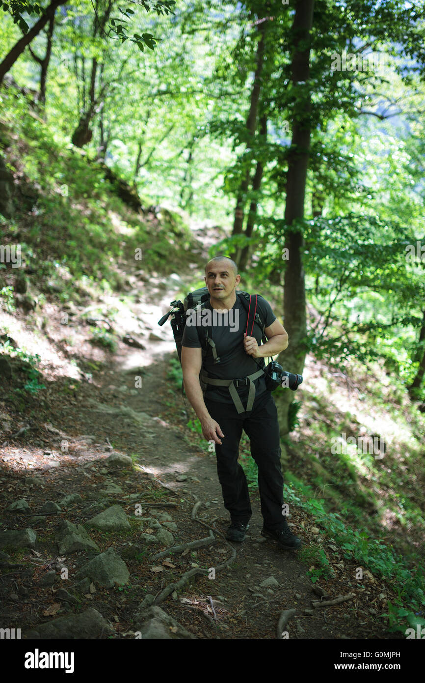 Professional nature photographer hiking on a trail in mountains Stock ...