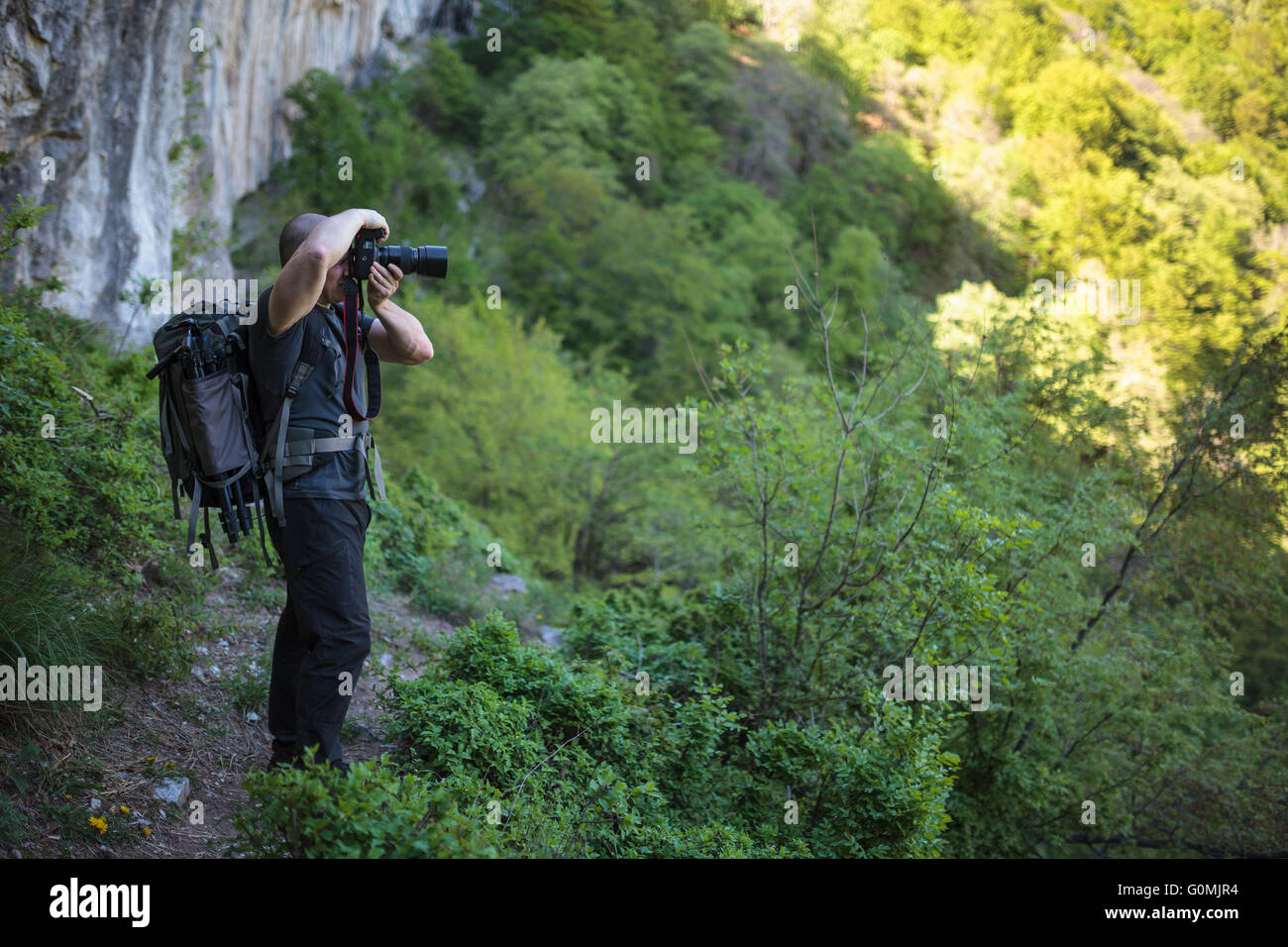 Professional nature photographer hiking on a trail in mountains Stock ...