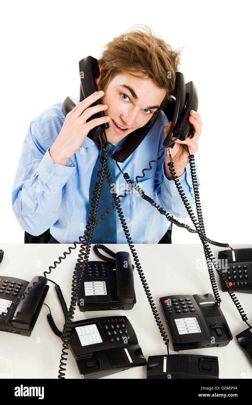 Young man in the office and answering several phones at the same time ...