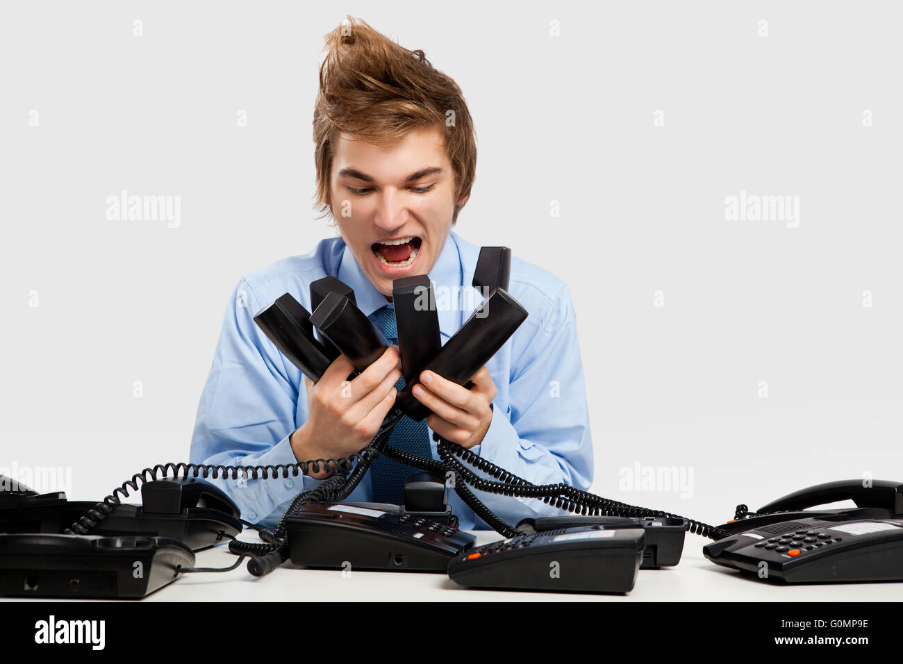 Young man holding and yelling to the phones Stock Photo - Alamy