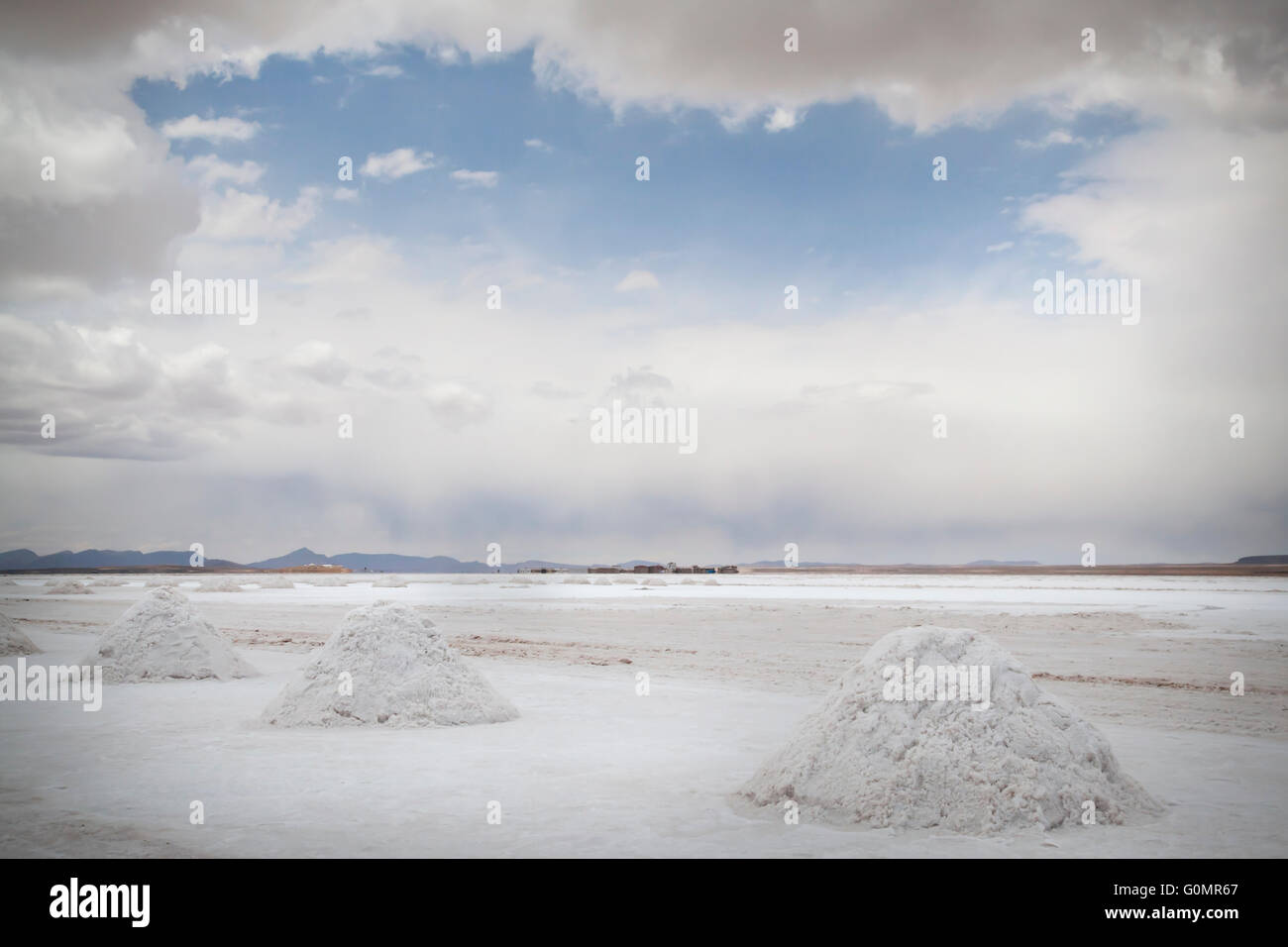 A break in the clouds shows blue sky above the Bolivian salt plains at ...