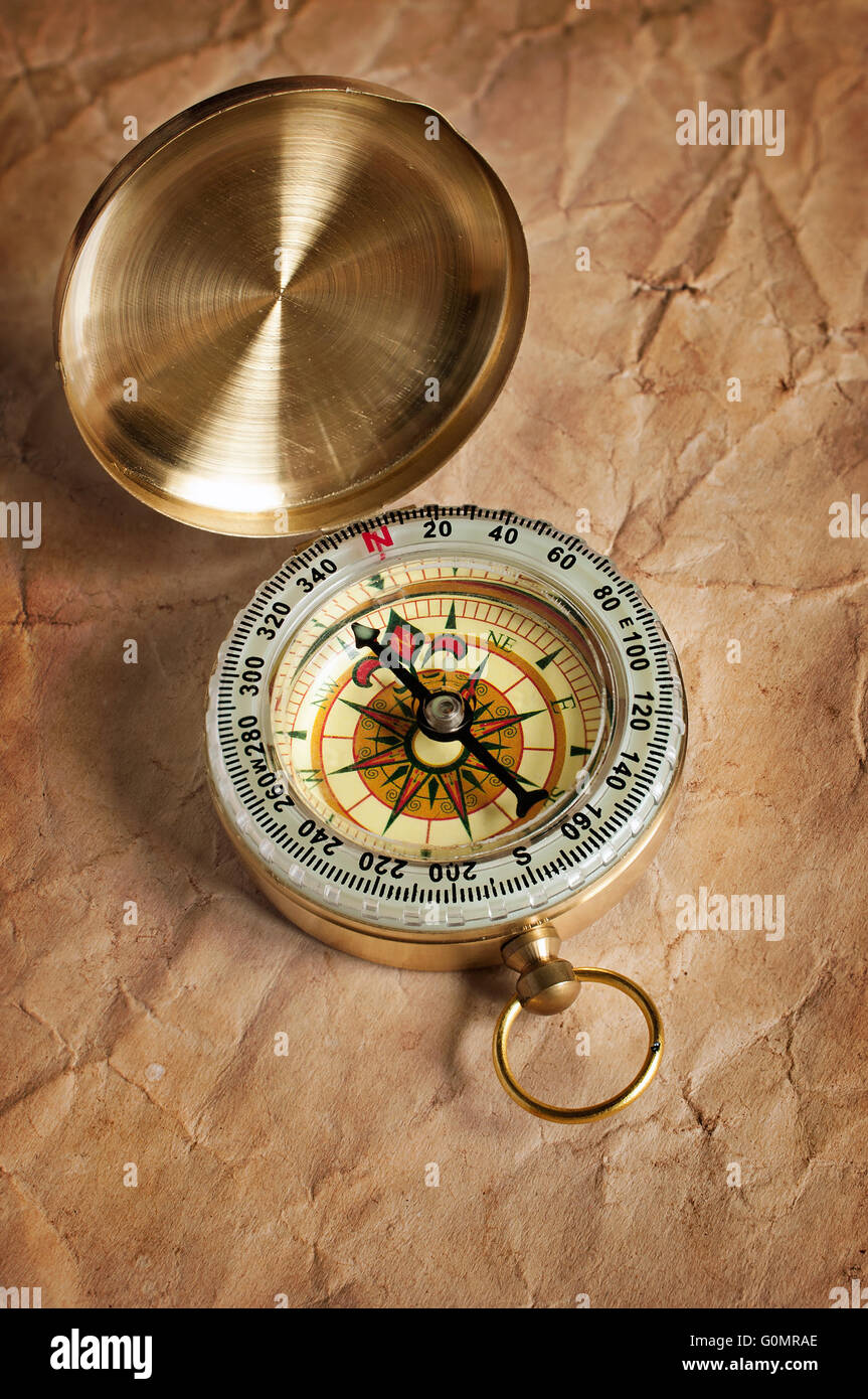 Retro brass compass on a paper background close-up Stock Photo - Alamy