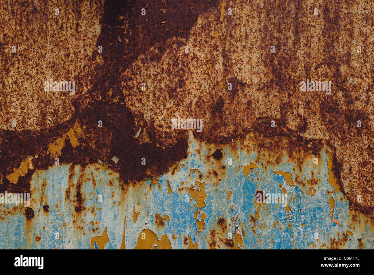 Detail of corroded metal plate with blue paint peeled of oxidized metal ...