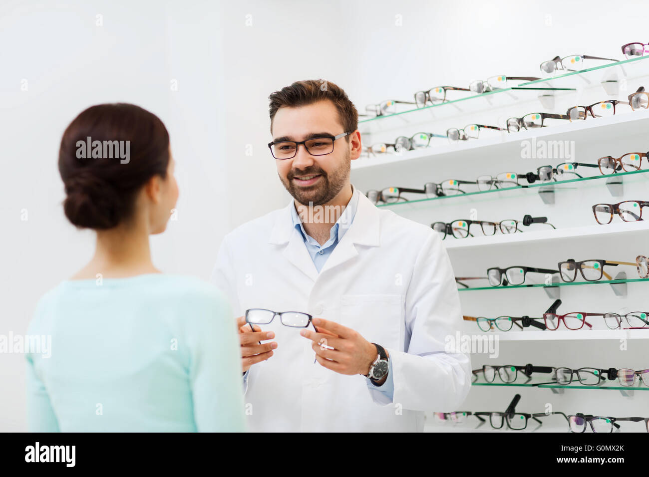 woman and optician showing glasses at optics store Stock Photo - Alamy