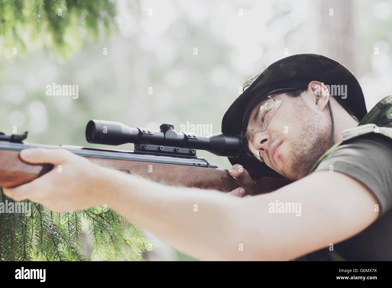 young soldier or hunter with gun in forest Stock Photo - Alamy