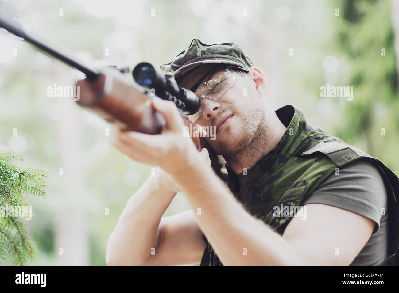 young soldier or hunter with gun in forest Stock Photo - Alamy