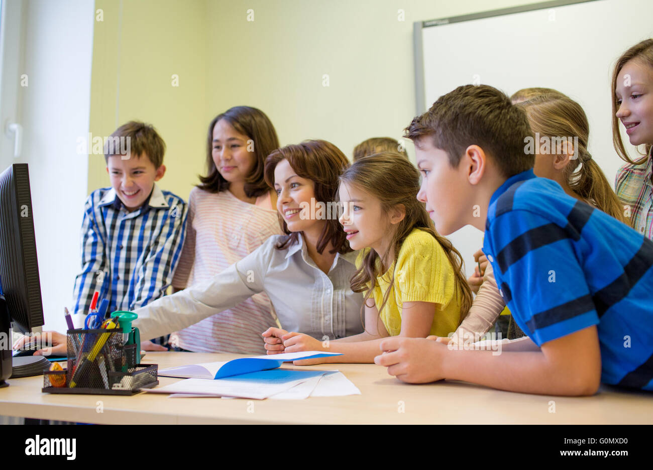 group of kids with teacher and computer at school Stock Photo - Alamy