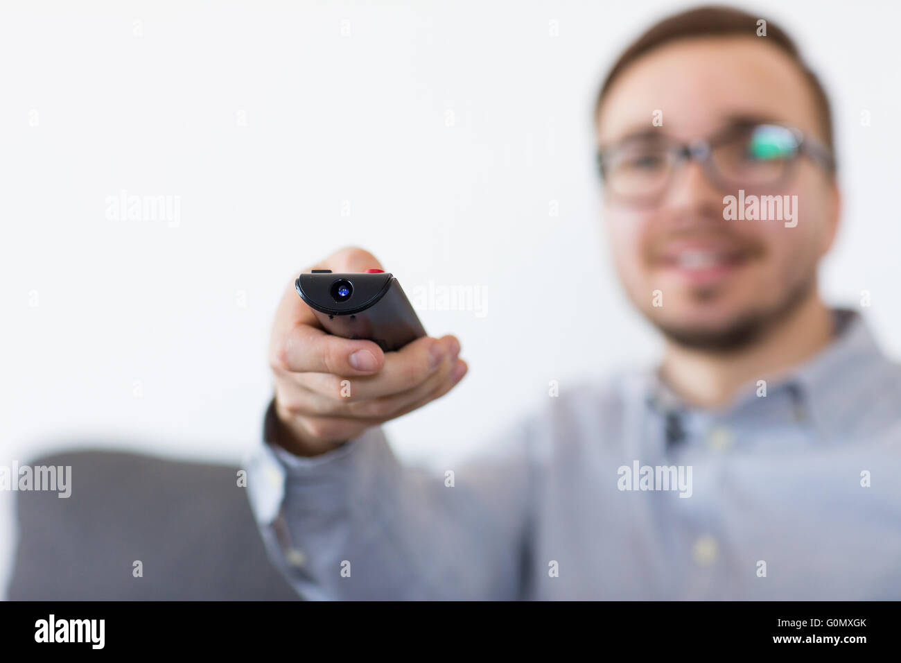 smiling man with tv remote control at home Stock Photo - Alamy