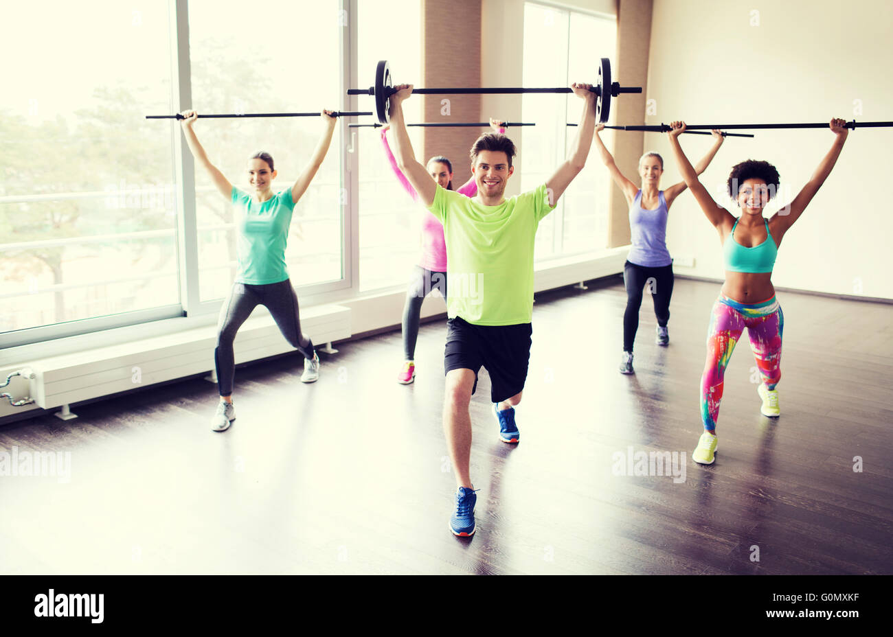 group of people exercising with bars in gym Stock Photo - Alamy