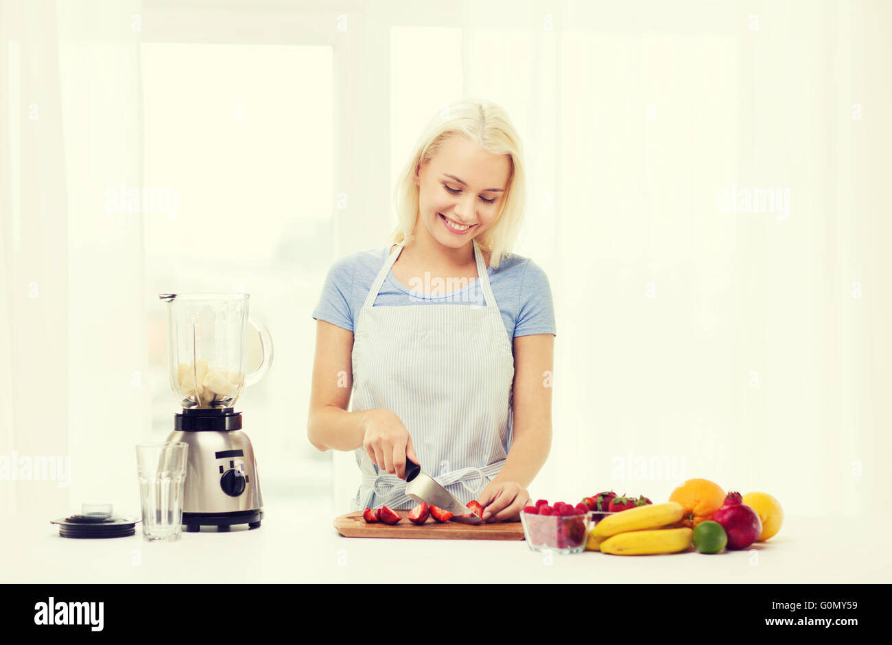 smiling woman with blender preparing shake at home Stock Photo - Alamy