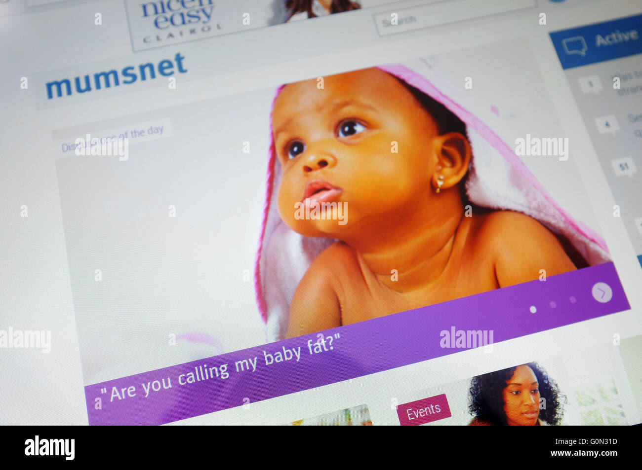 Pages on the Mumsnet website displayed on the screen of a tablet Stock ...