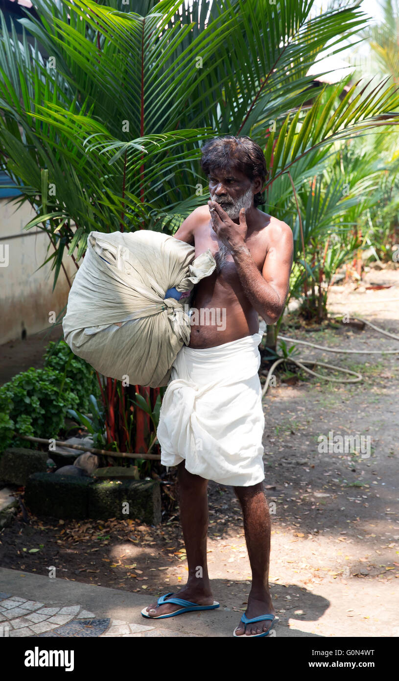 Indian man carrying laundry in a loin cloth in Cochin India Stock Photo ...