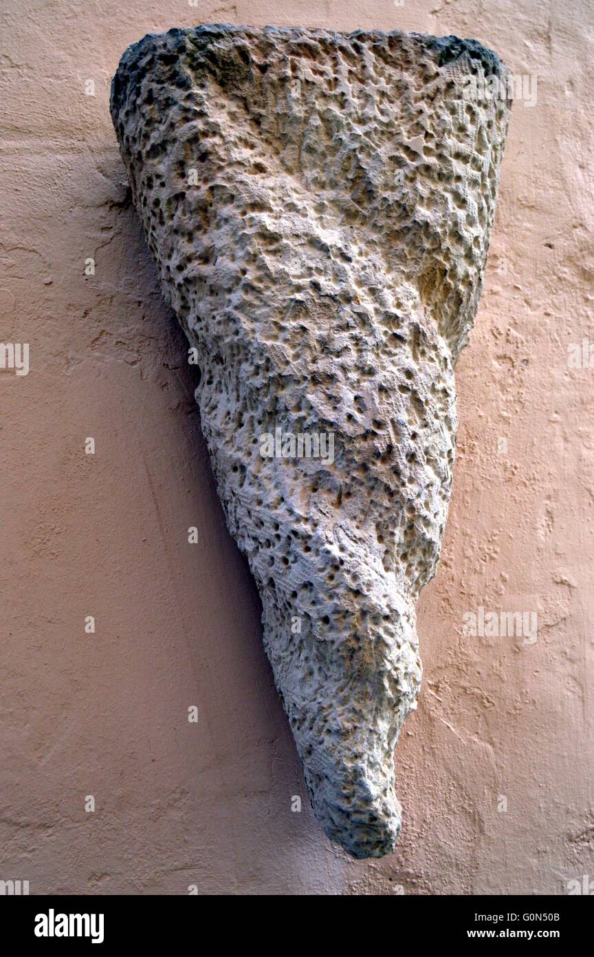 An electric wall lamp in the shape of stone cone on a mauve wall Stock ...