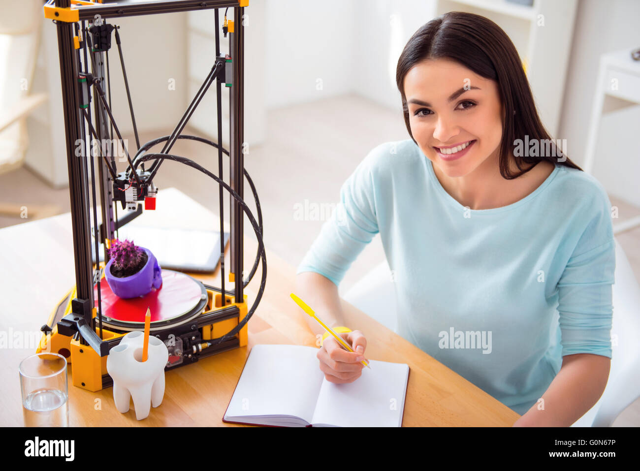 Pleasant smiling woman using 3d printer Stock Photo - Alamy