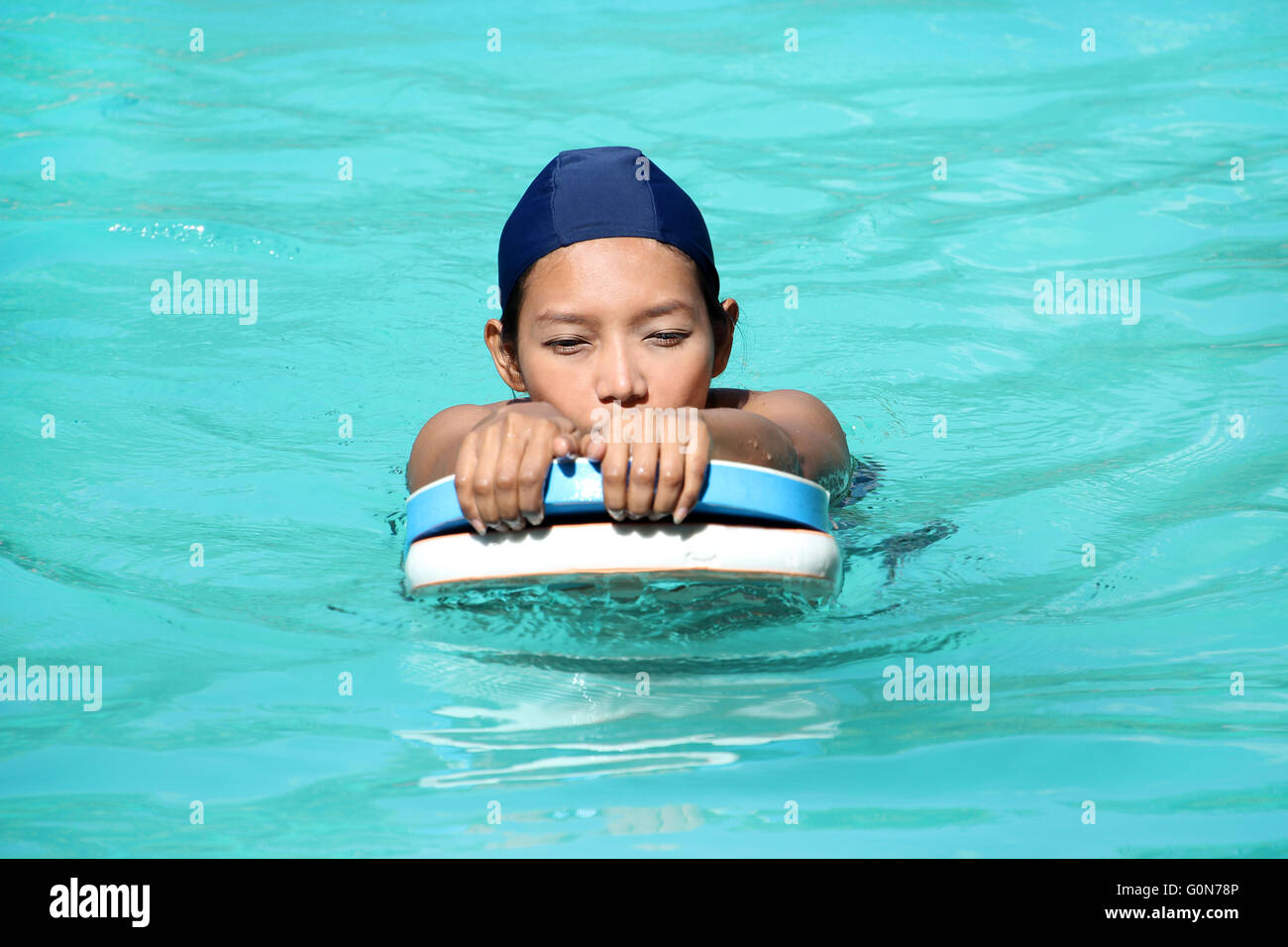 Woman learning to swim in the pool with board Stock Photo - Alamy