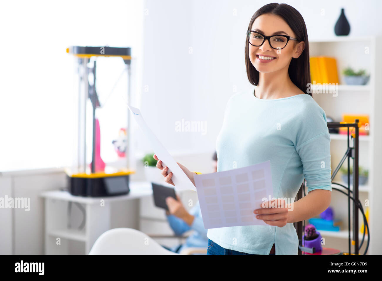 Positive woman holding papers Stock Photo - Alamy