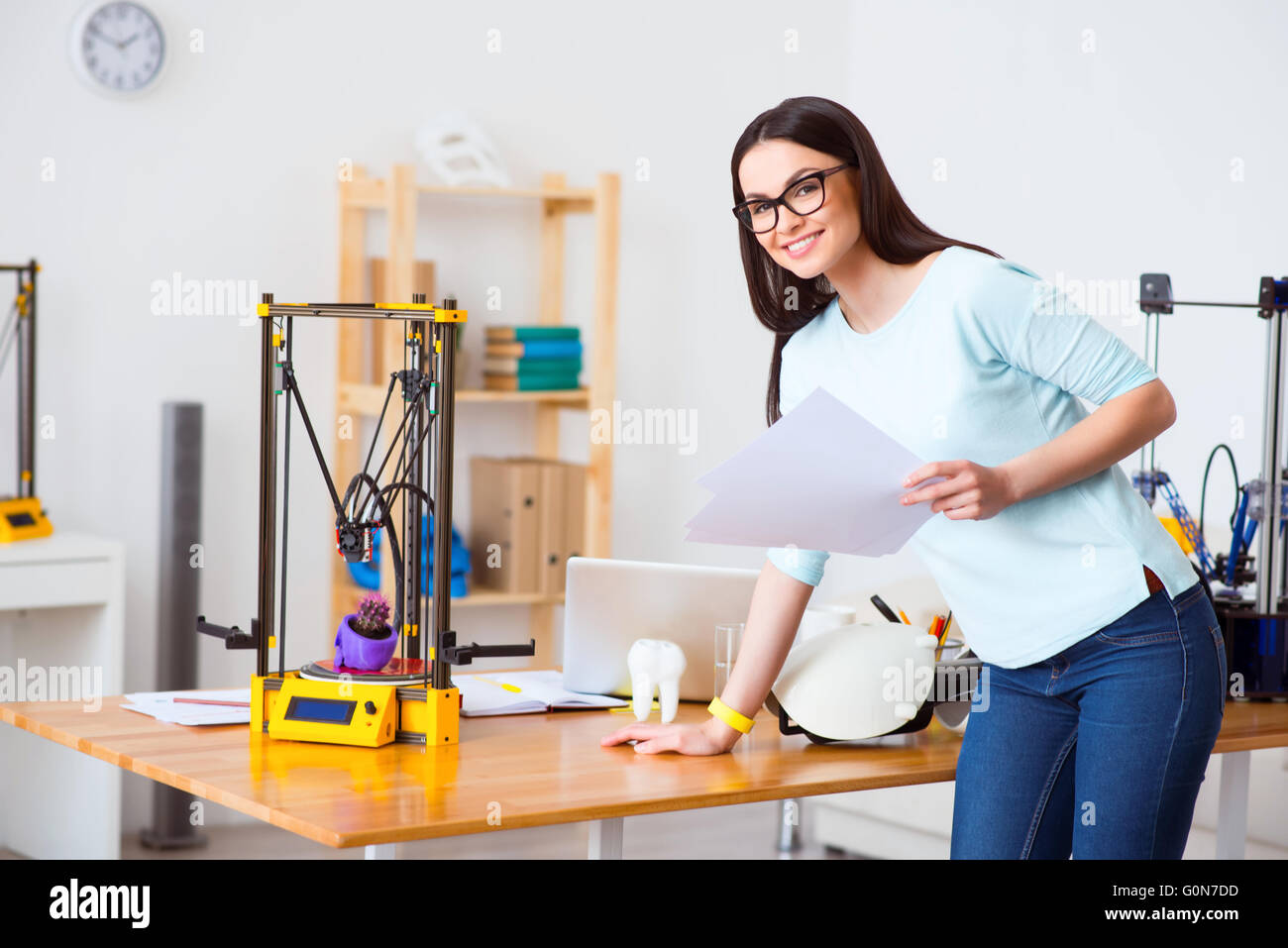 Positive girl holding papers Stock Photo - Alamy