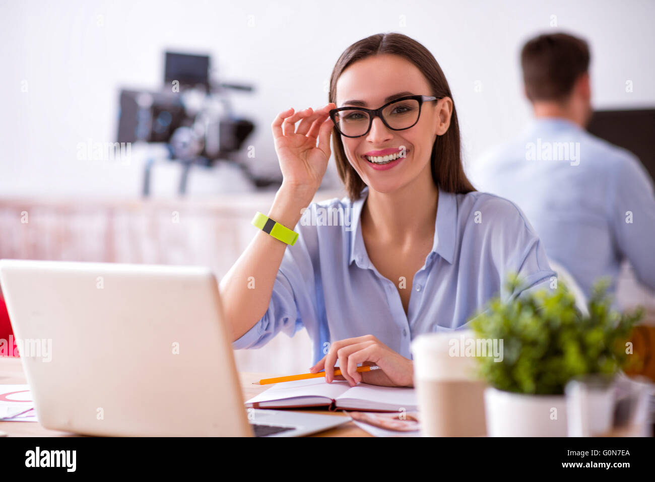 Pleasant woman sitting at the table Stock Photo - Alamy
