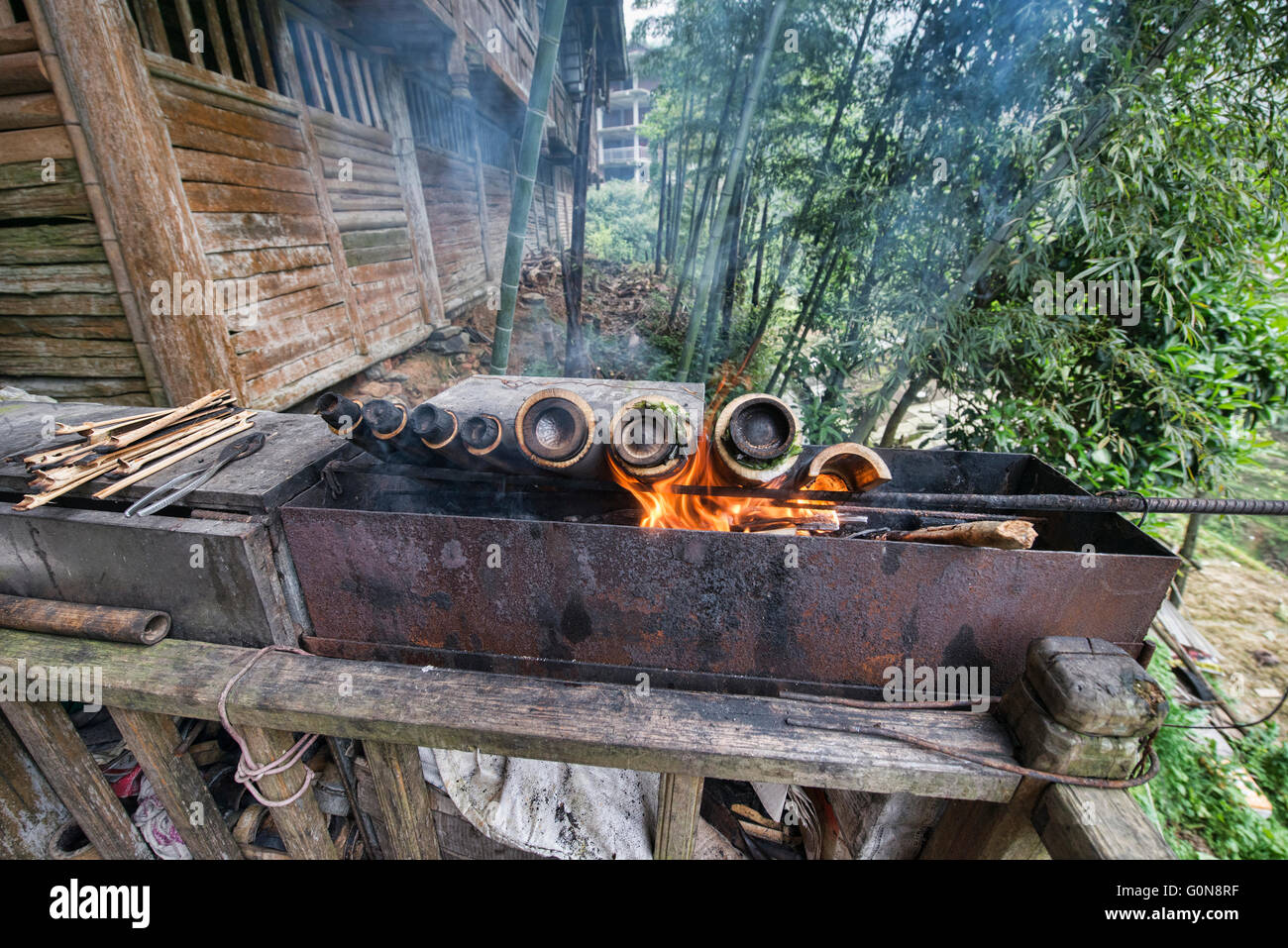 Cooking bamboo stuffed with rice and chicken, a local speciality in the ...