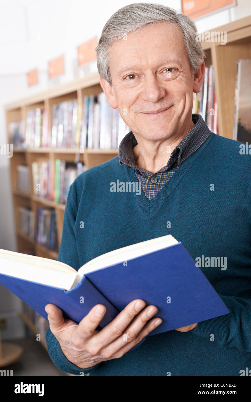Mature Male Student Reading Book In Library Stock Photo - Alamy