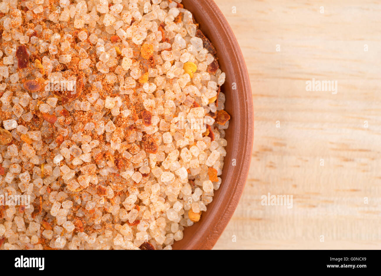 Top close view of a small dish filled with ground salt, red chili ...