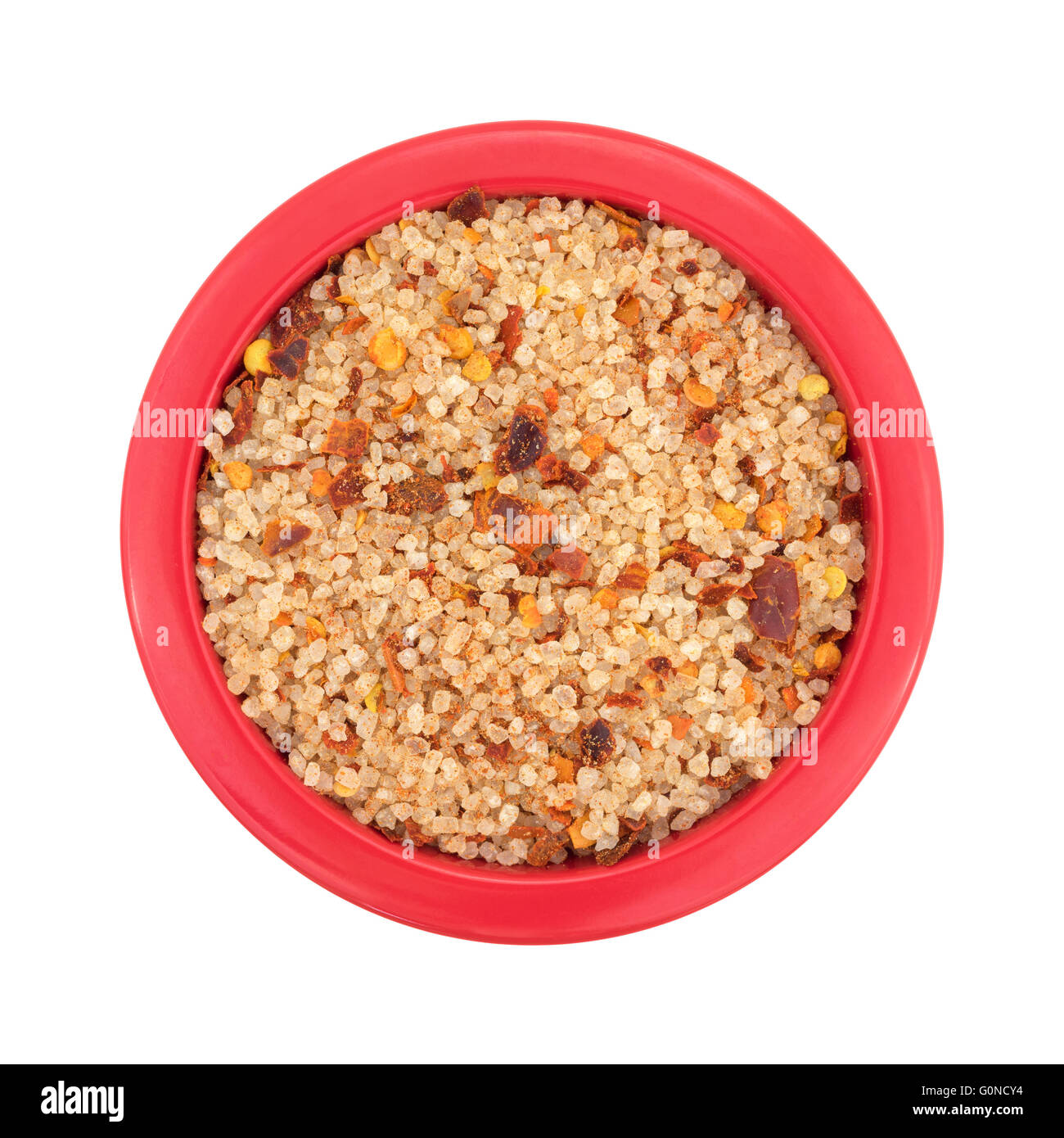 Top view of a small red dish filled with ground salt, red chili peppers ...