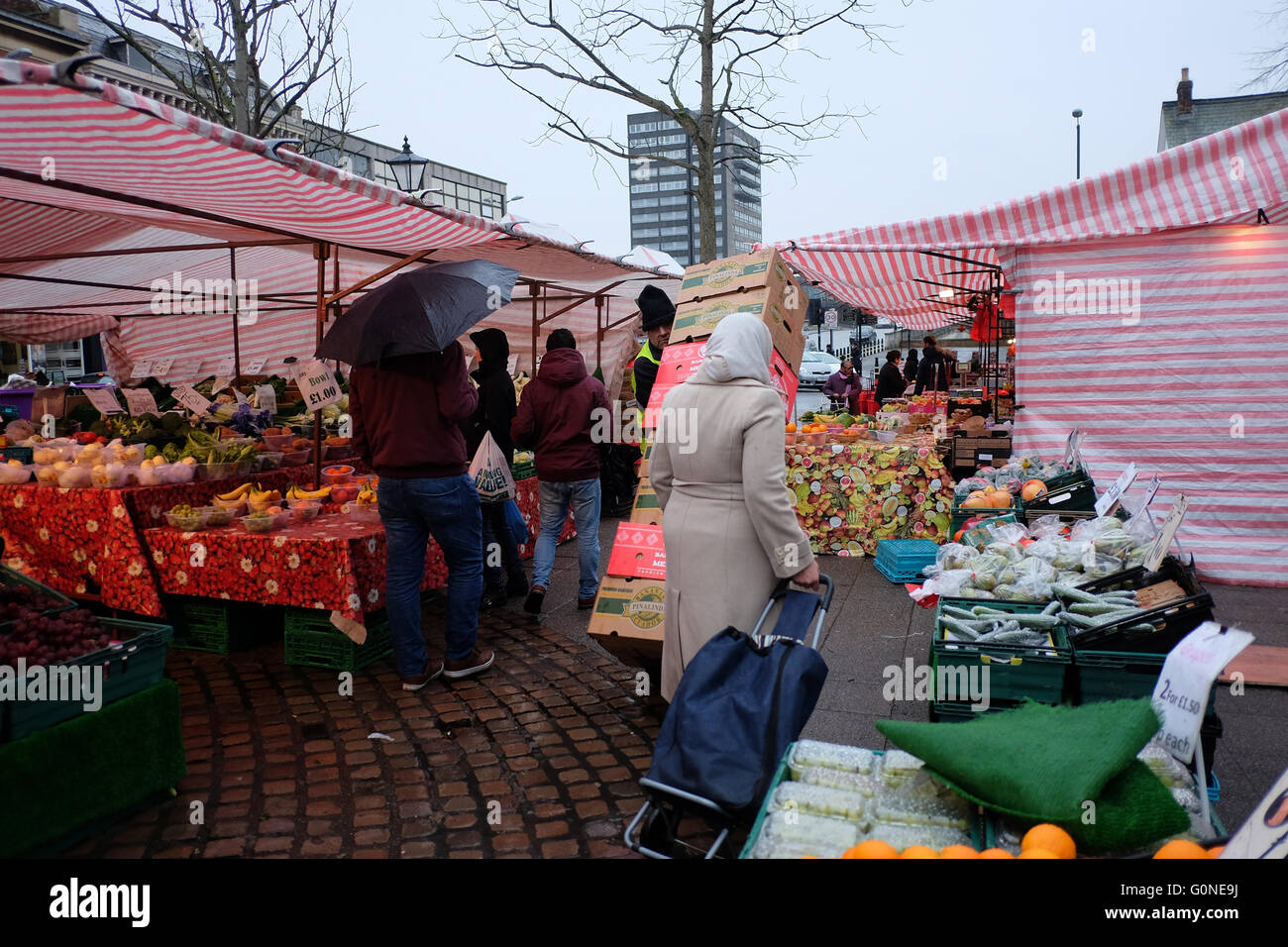 Man pushing a trolley stacked high with fruit boxes through Bedford ...