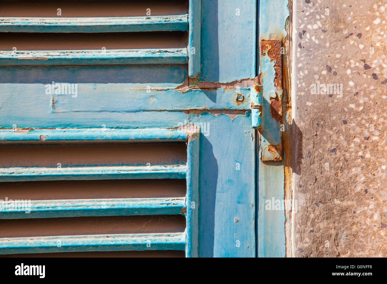 A blue wood window with a rusty hinge Stock Photo - Alamy