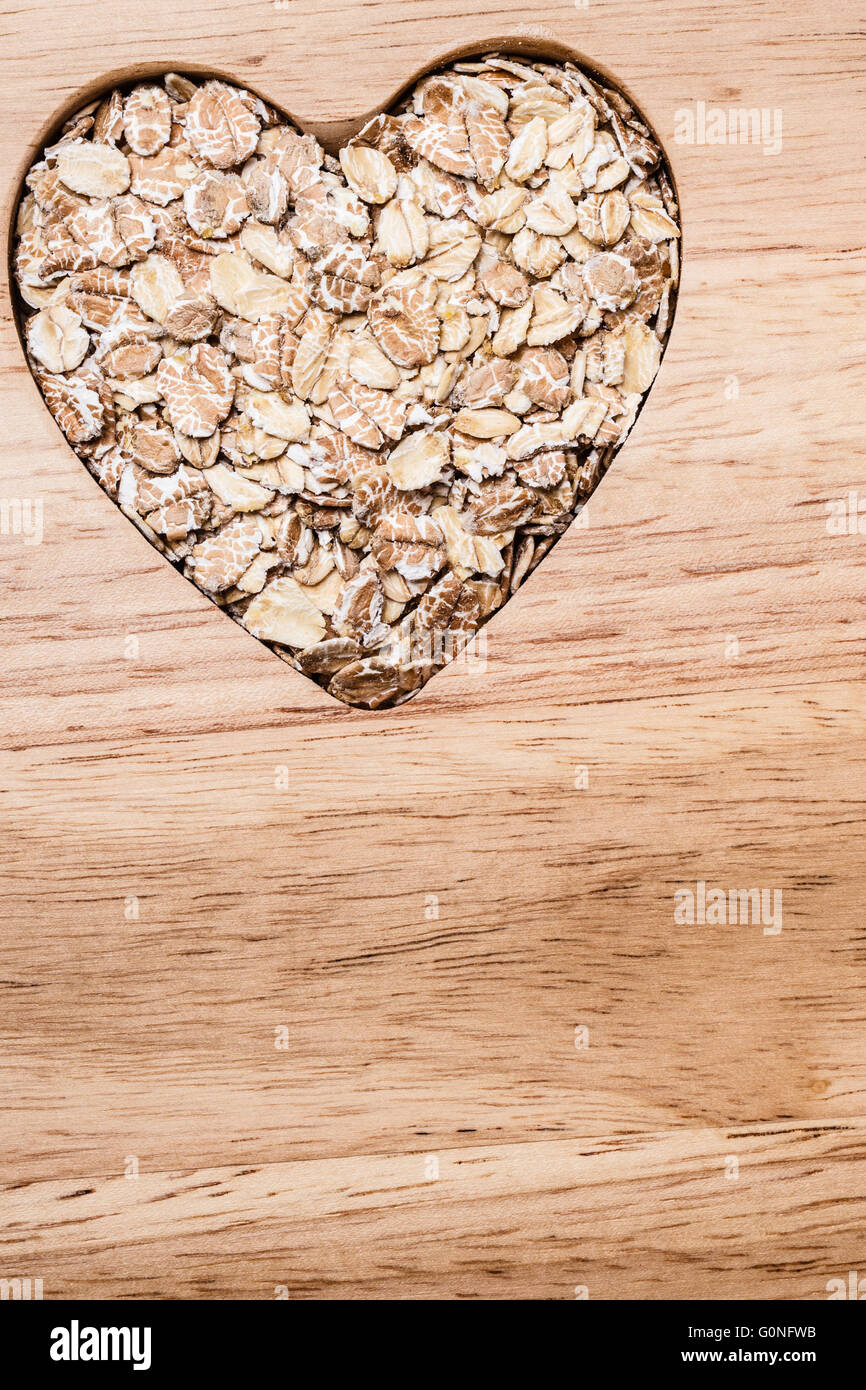 Dieting healthcare concept. Oat cereal oatmeal heart shaped on wooden ...