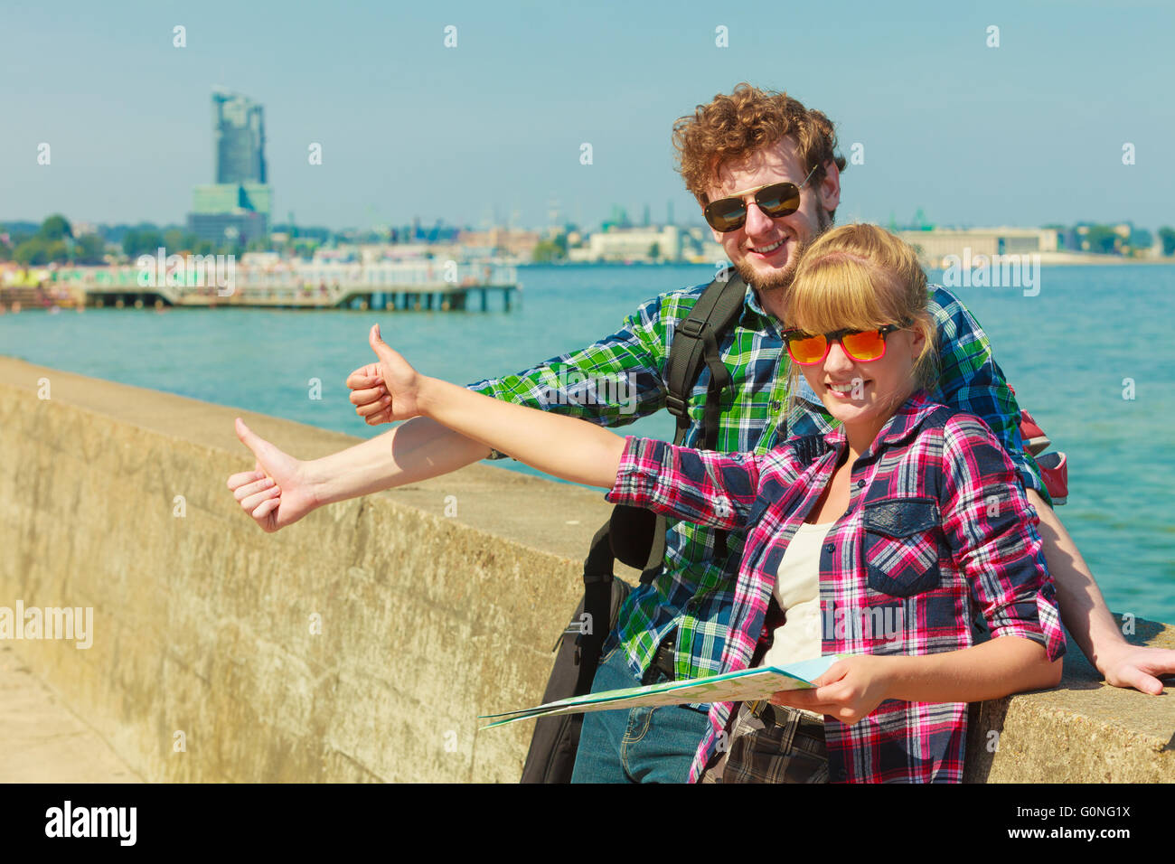 Adventure, summer, tourism. Young couple backpacker hitchhiker with map ...
