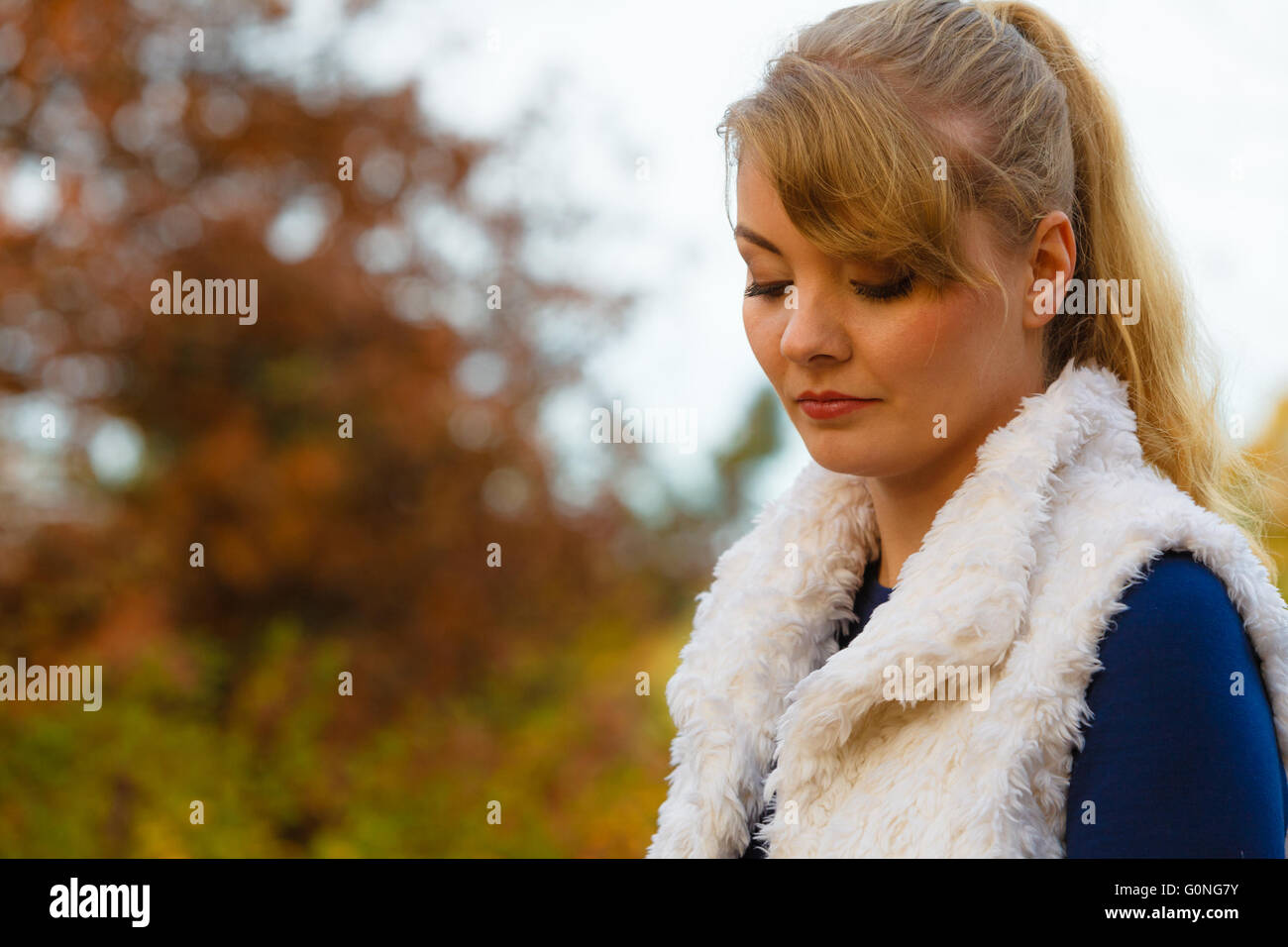 Sad woman walking in fall forest park. Gorgeous blonde young girl ...